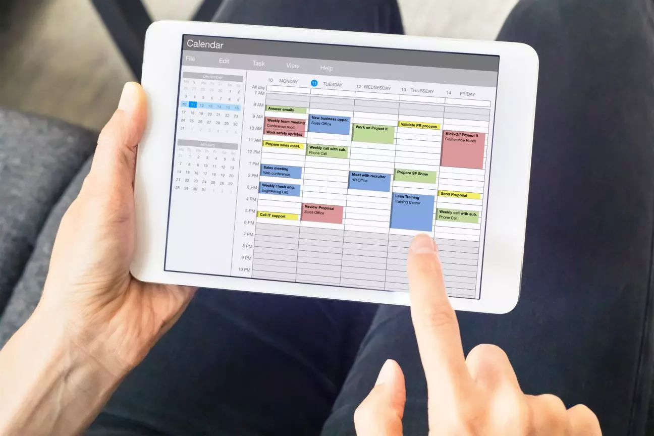 Vīrietis izmanto savu kalendāra lietotni, lai ieplānotu savas daudzās, daudzās aktivitātes.